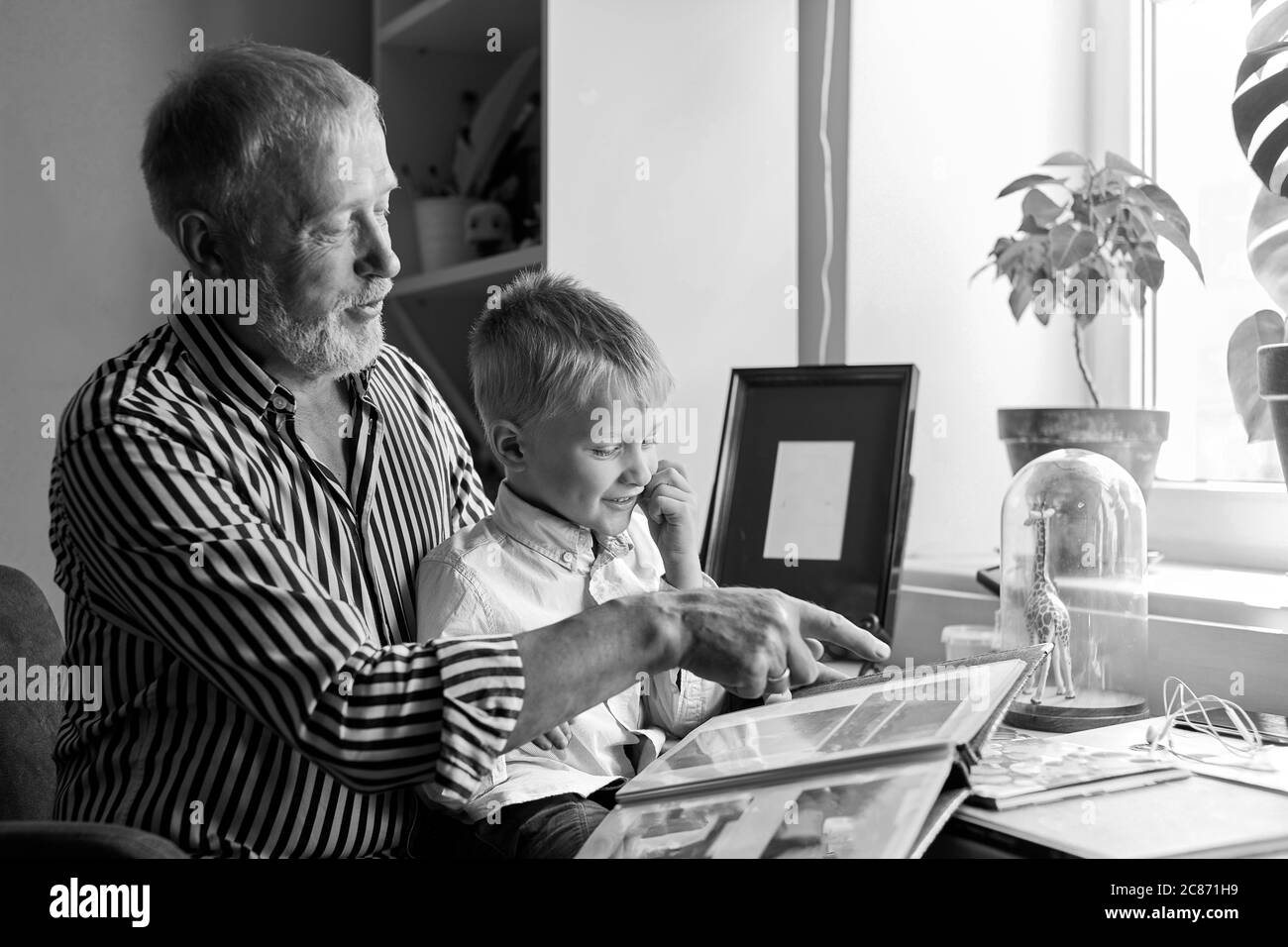 Grandfather and grandson on sofa at home. Grandpa and children watching ...