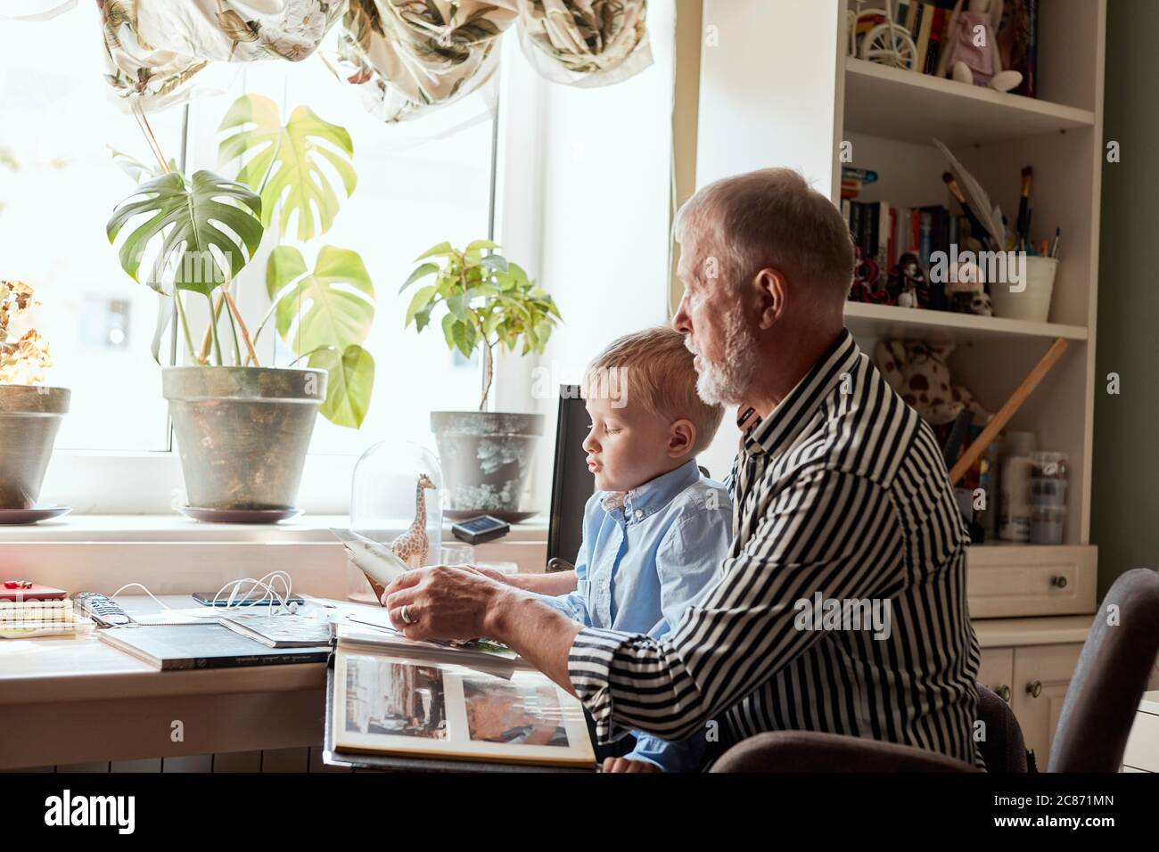Grandfather and grandson on sofa at home. Grandpa and children watching ...
