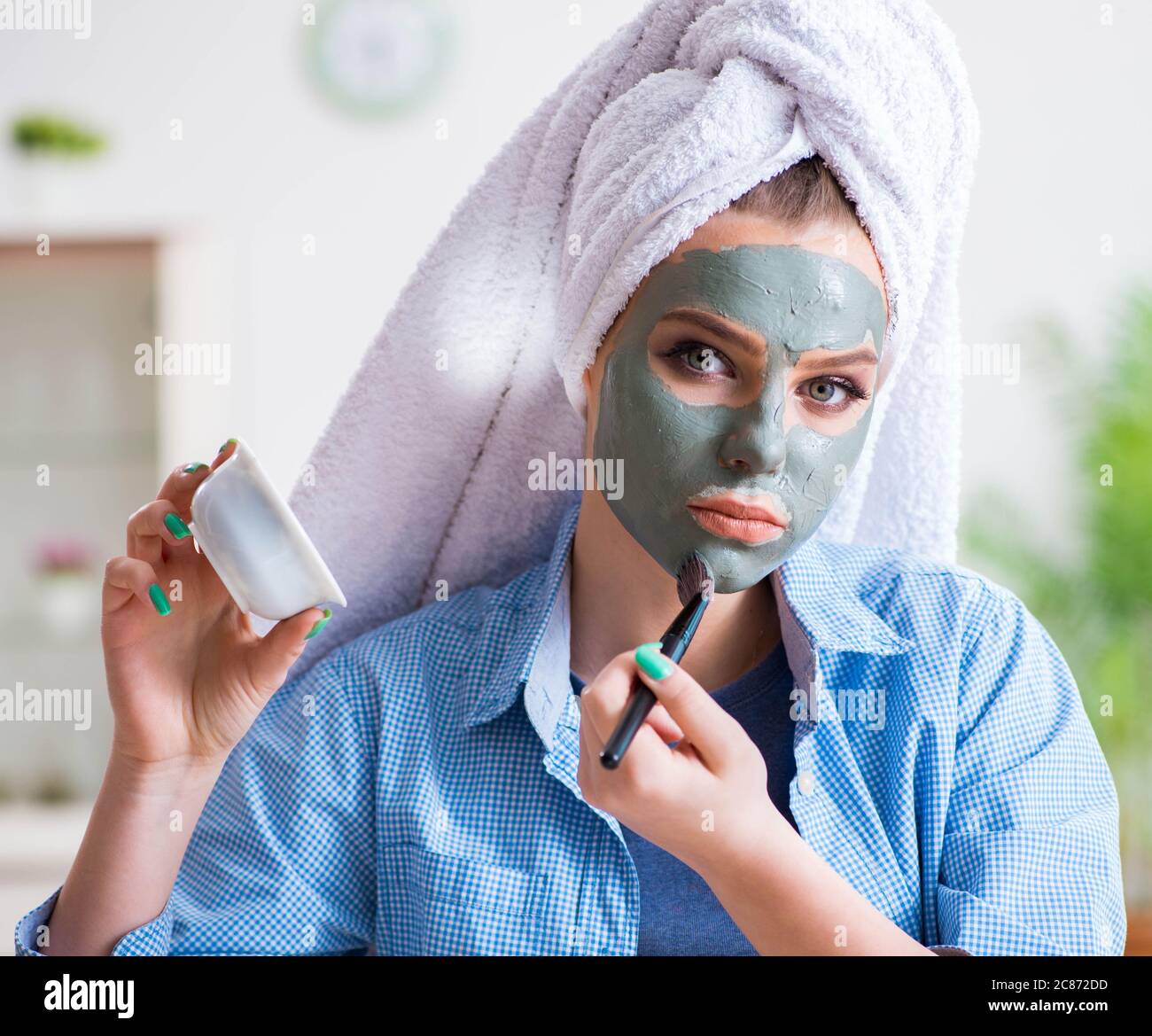 The woman applying clay mask with brush at home Stock Photo - Alamy