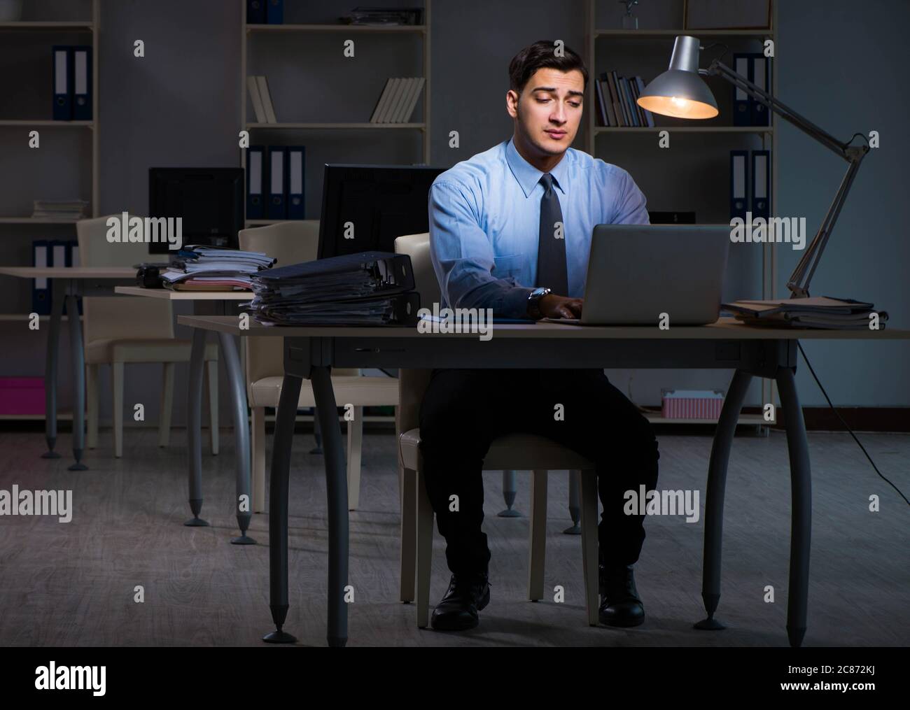 The employee working late at night at important report Stock Photo - Alamy