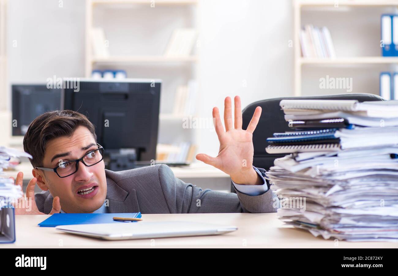 The overloaded with work employee under paperwork burden Stock Photo ...