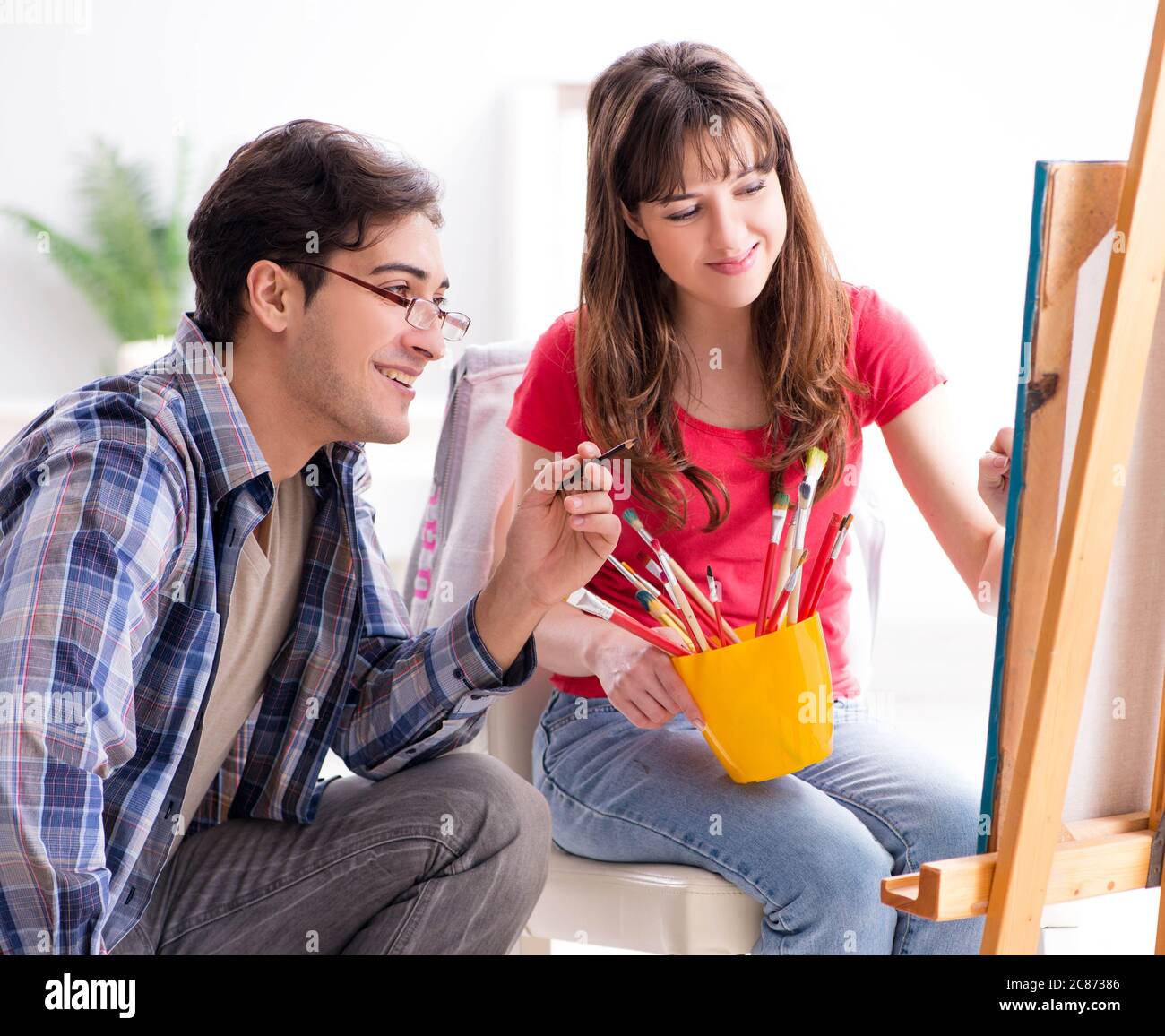 The artist coaching student in painting class in studio Stock Photo - Alamy