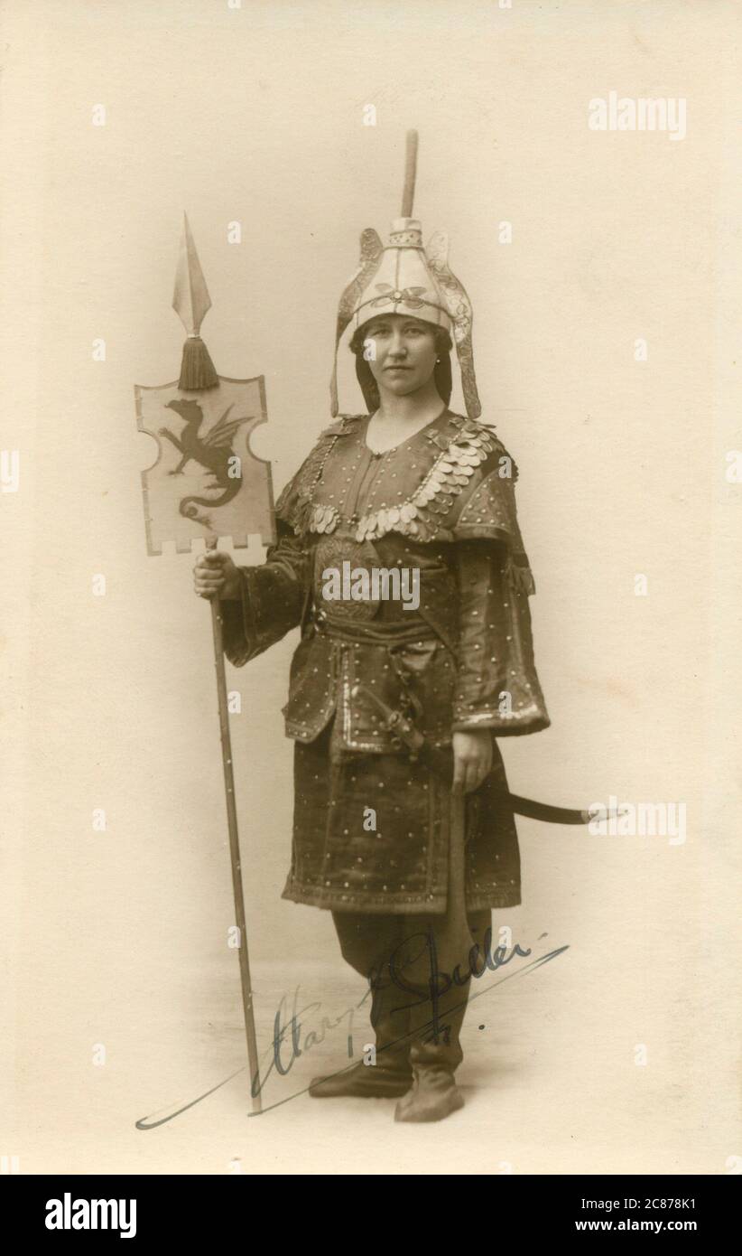 A woman in an interesting militaristic exotic costume, holding a ...