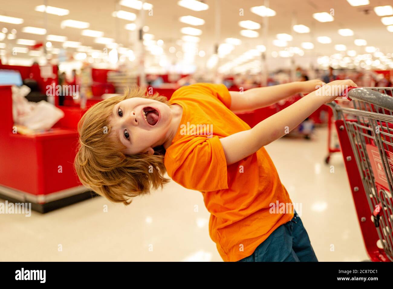 Funny customer boy child holdind trolley, shopping at supermarket ...