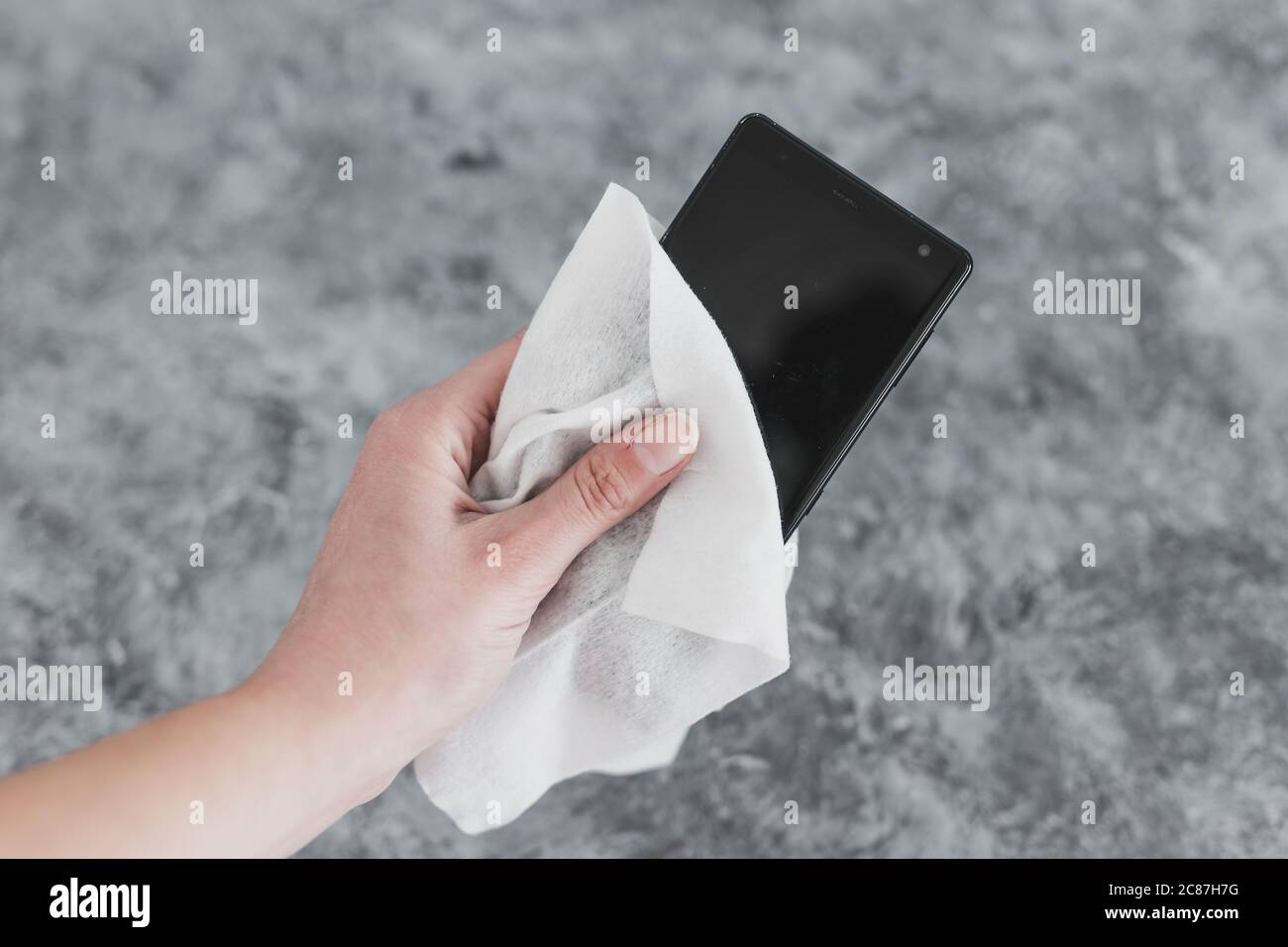 the new normal after covid-19 and concet of sanitizing surfaces, hand cleaning smartphone with ...