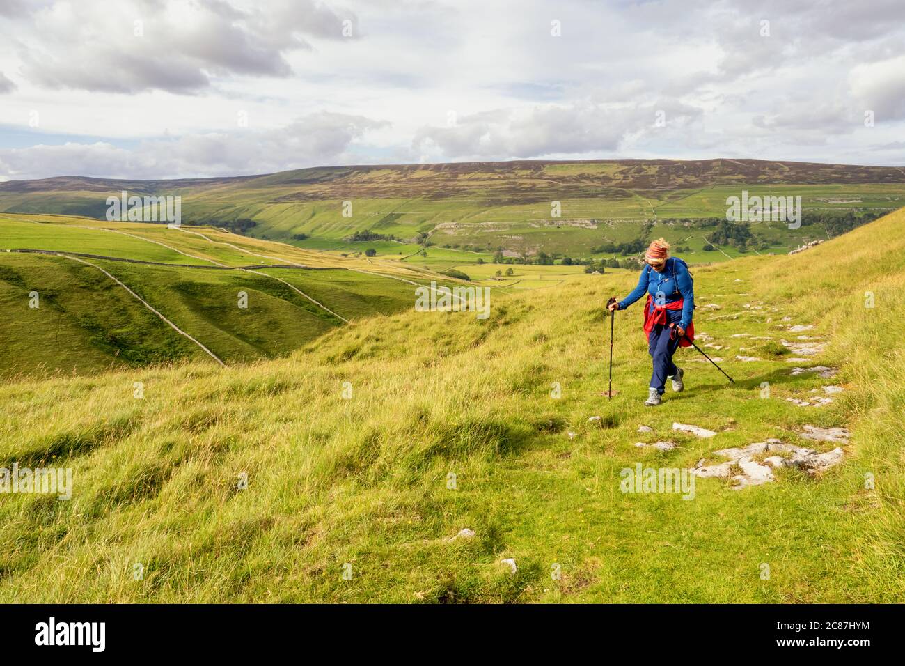 Female hill walker dressed in blue walking back to Malham Tarn climbs ...