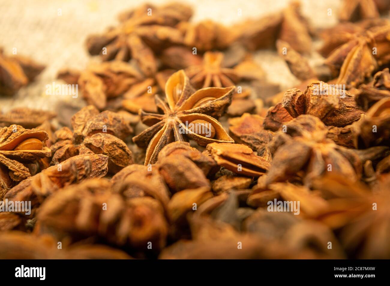 A pile of star anise on a background of burlap with a rough texture ...