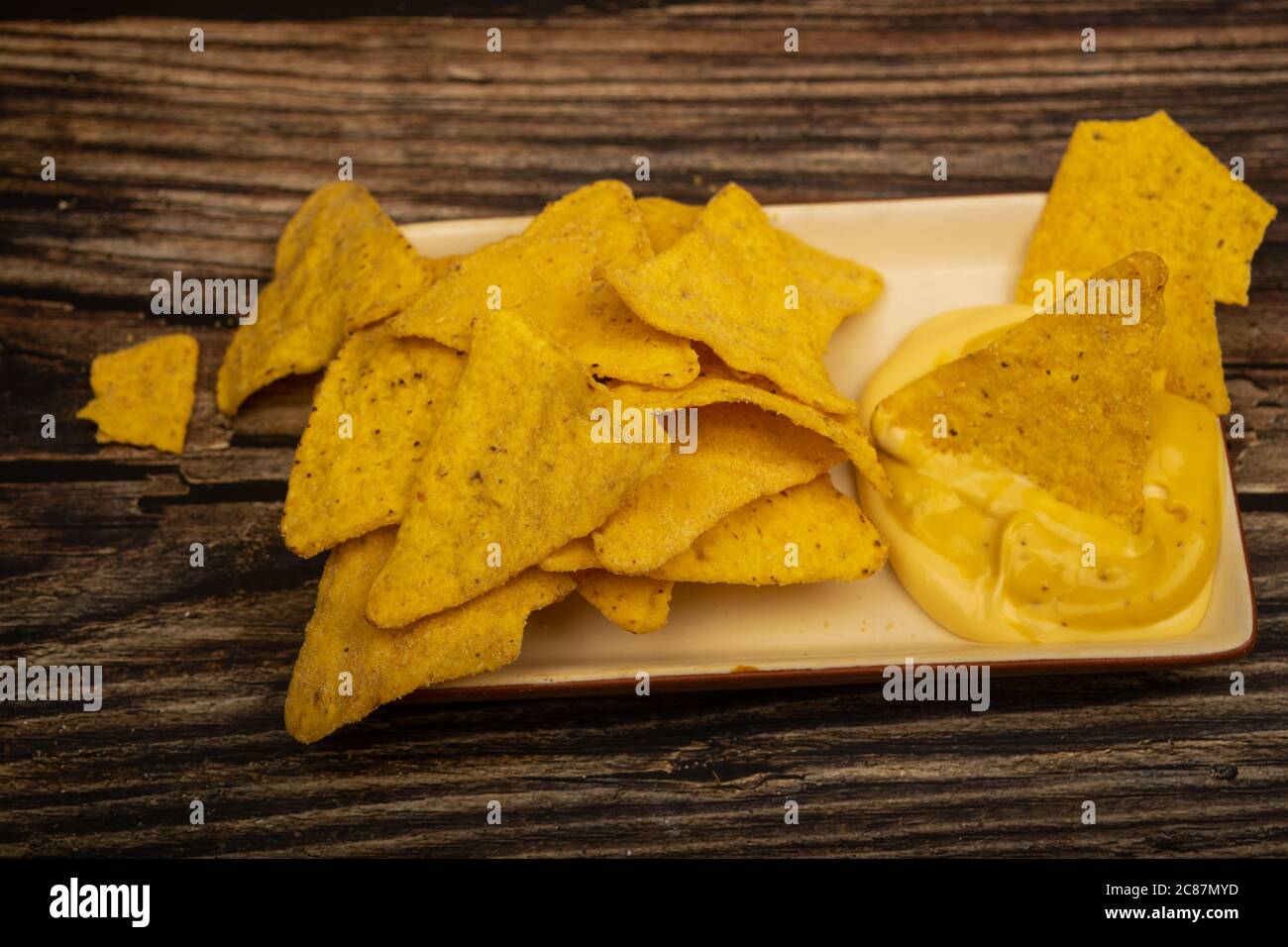 Corn chips with cheese sauce on a wooden background. Close up Stock ...