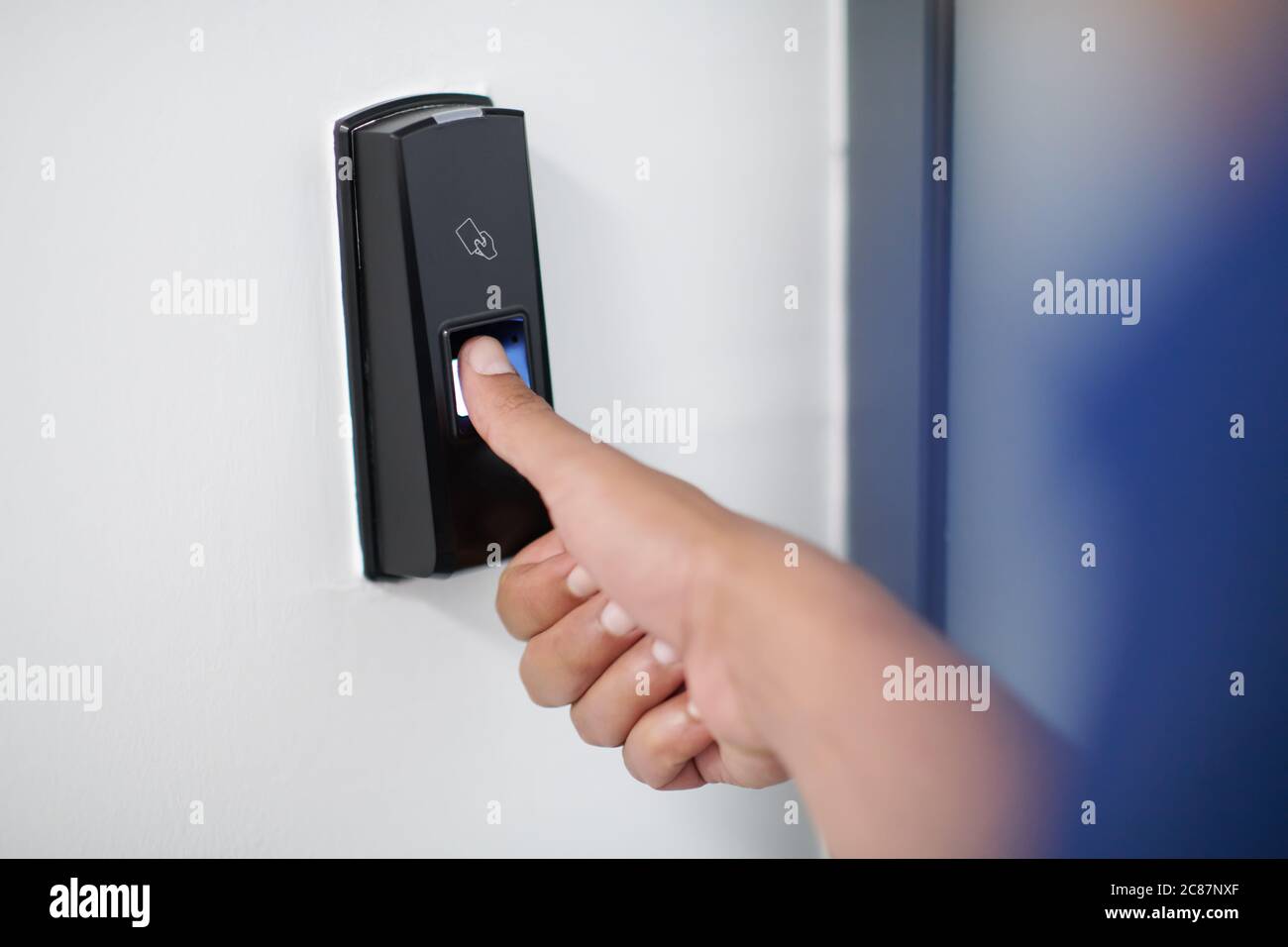 man pressing fingerprint scanner on alarm system indoors Finger print scan for unlock door ...