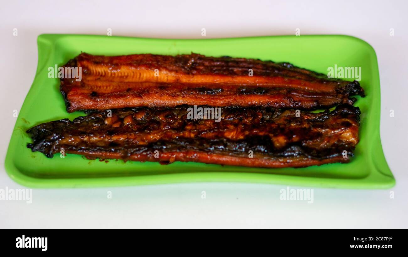 Grilled unagi or eel on green plate. White background Stock Photo - Alamy