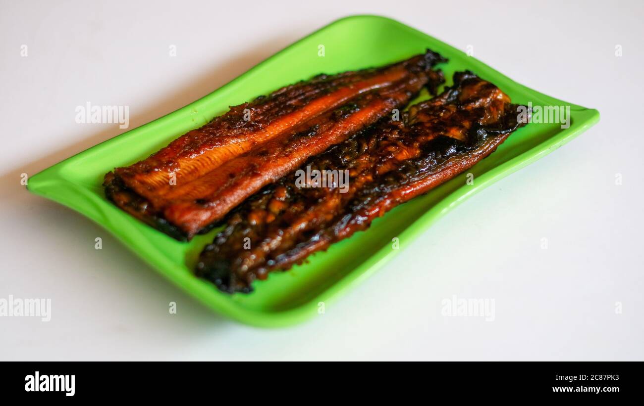 Grilled unagi or eel on green plate. White background Stock Photo - Alamy