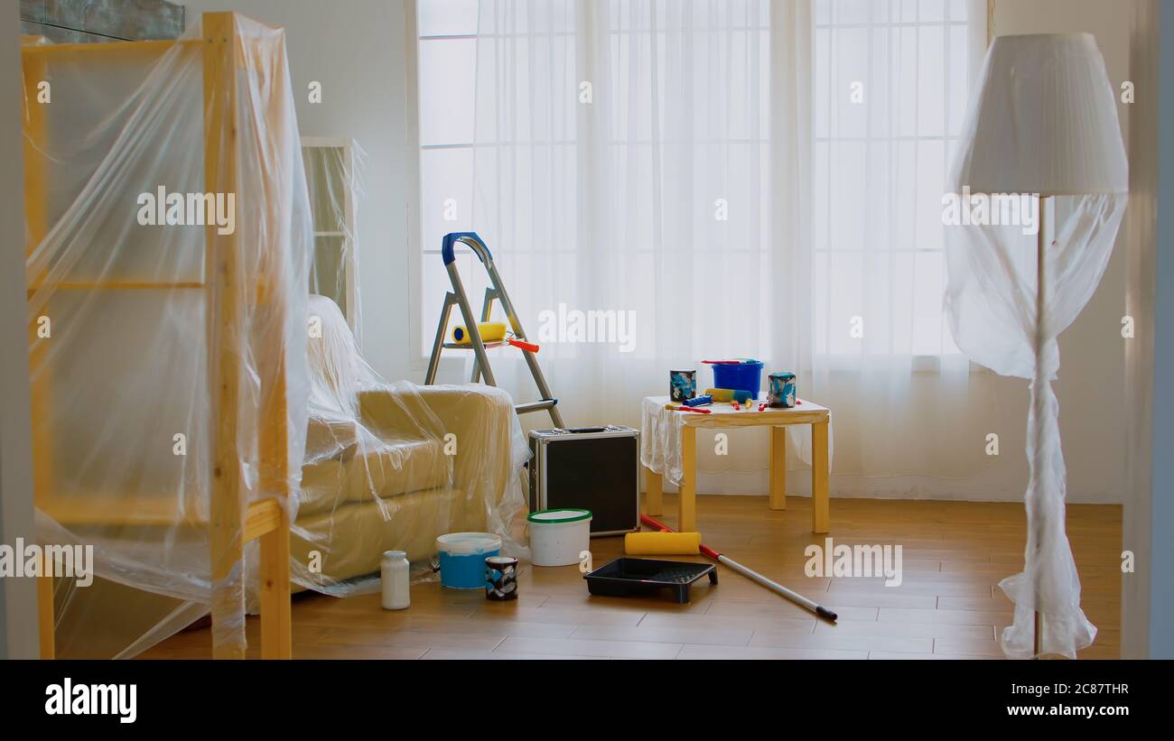 Roller brush on ladder during apartment renovation. Plastic sheet. Home ...