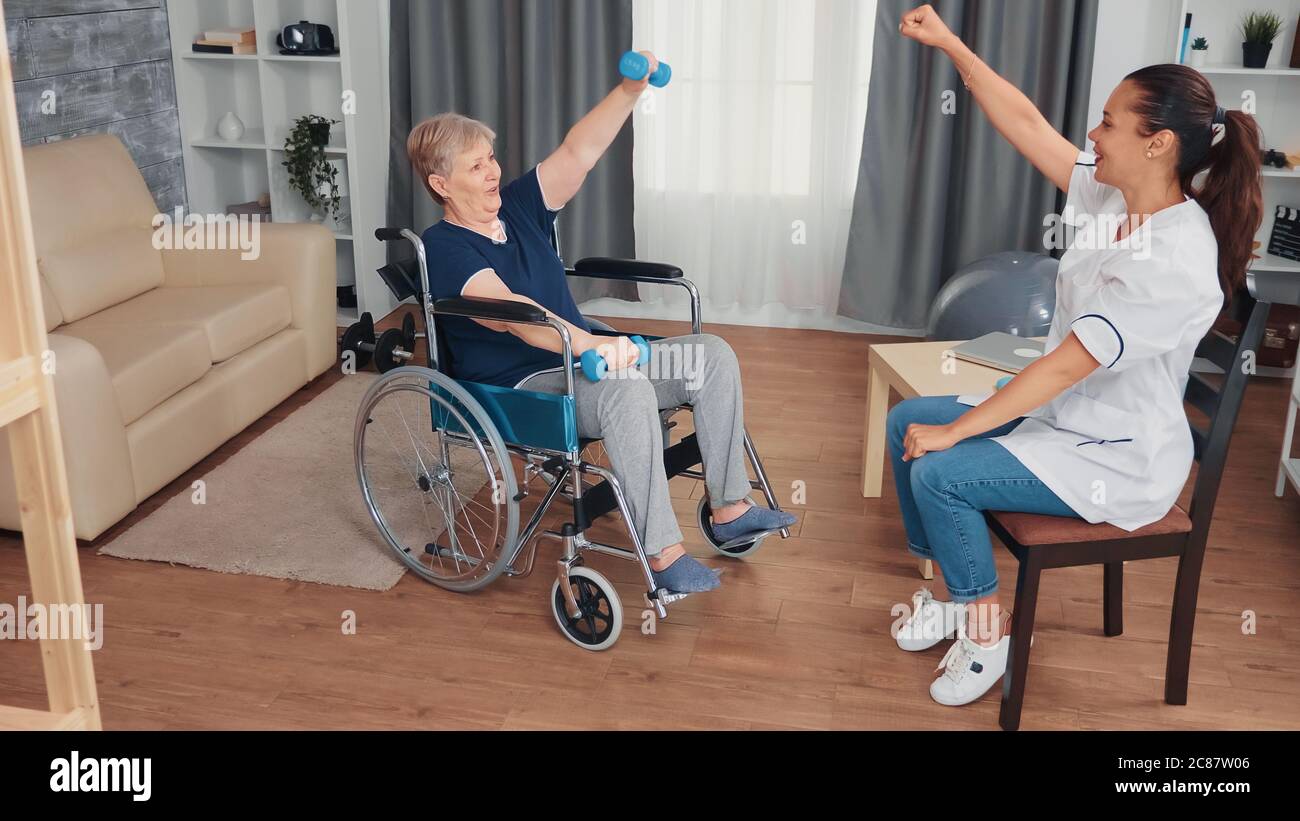 Invalid grandmother in wheelchair doing recovery therapy with doctor ...