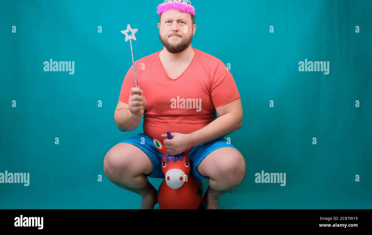 handsome bearded freaky man in a pink T-shirt with a deadema on his ...