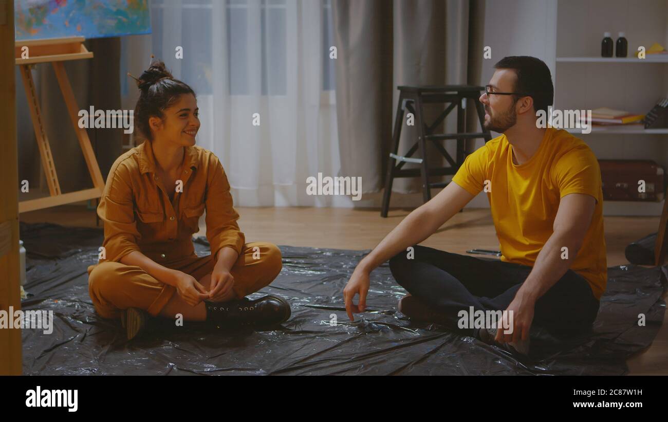 Couple of artists talking with each other in art studio Stock Photo - Alamy