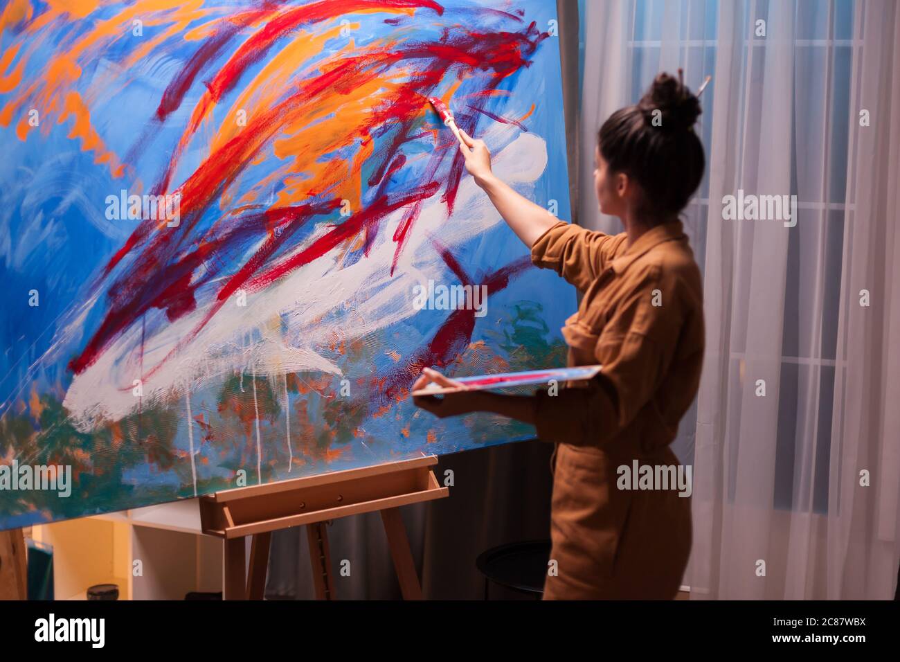 Successful artist working peacefully on masterpiece painting. Modern ...