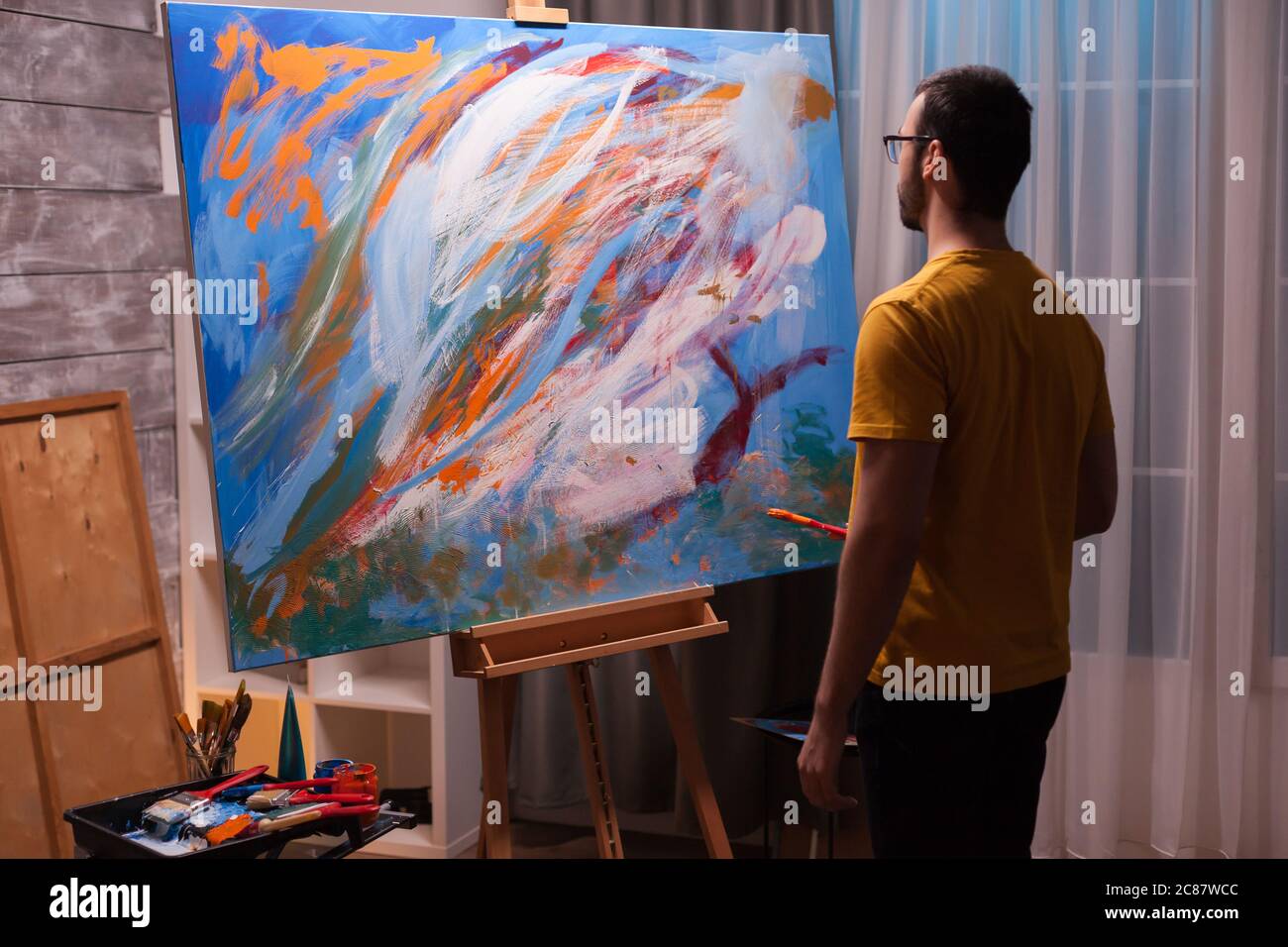 Successful artist in front of masterpiece oil painting in art workshop ...