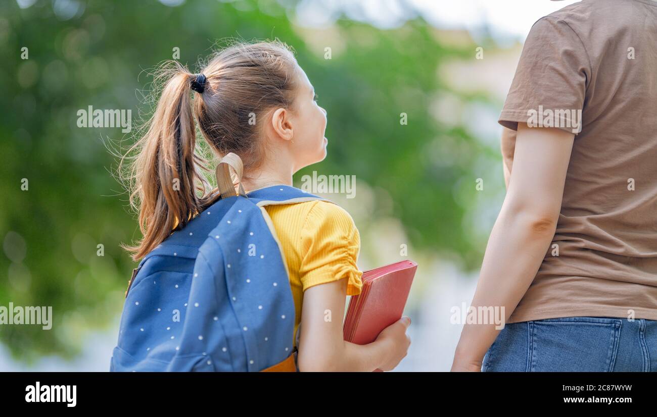 Parent and pupil of secondary school going hand in hand. Woman and girl ...