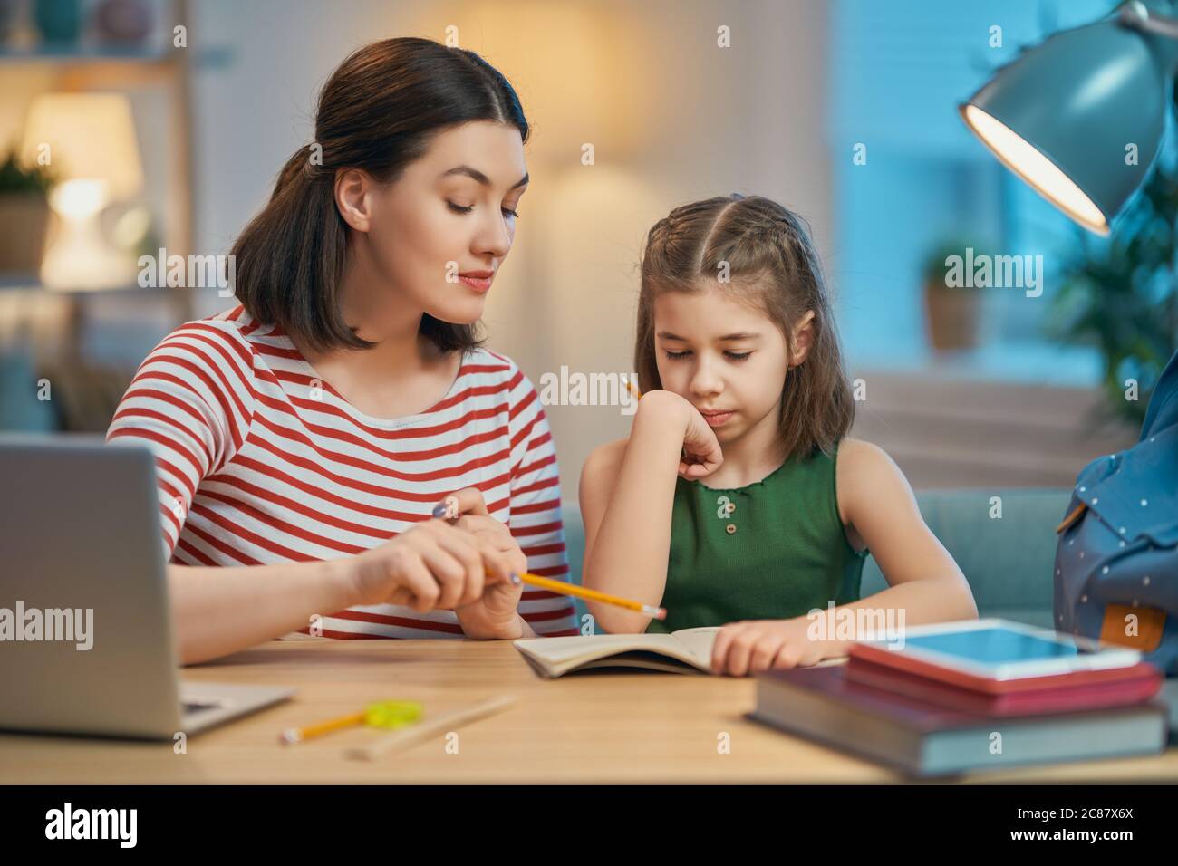 Back to school. Happy child is sitting at desk. Girl doing homework ...