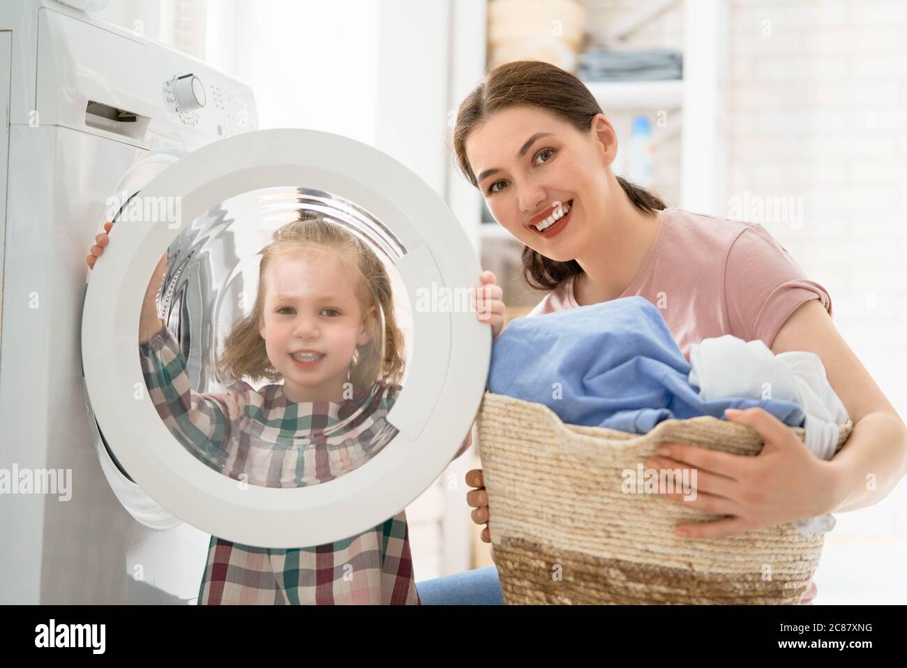 Beautiful young woman and child girl little helper are having fun and ...