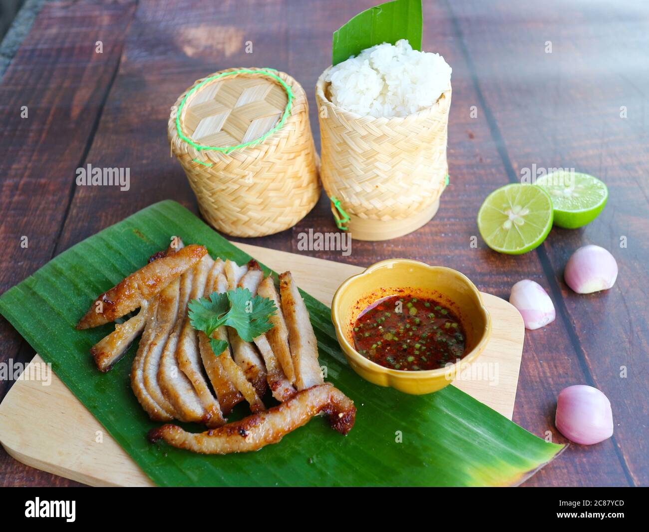 Grilled pork neck with spicy sauce served on wooden tray and sticky ...