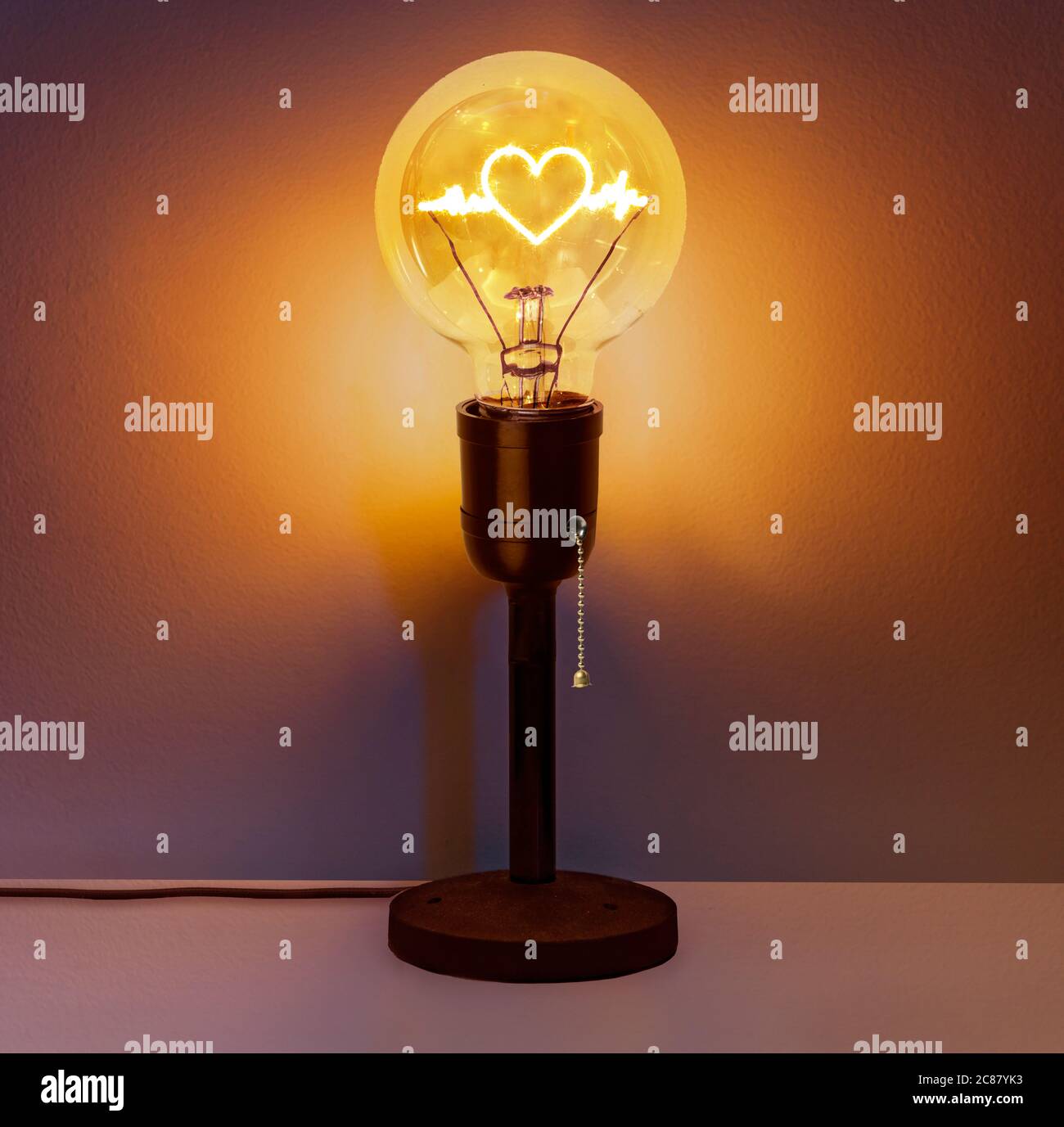 Love Heart Turned On In Light Bulb Glowing Stock Photo - Alamy