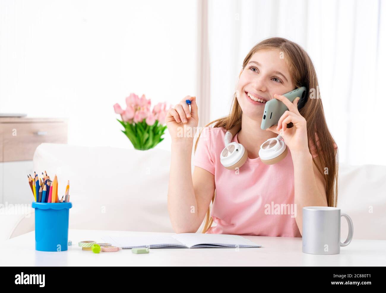 Adorable girl making calls to her school friends in free time Stock ...
