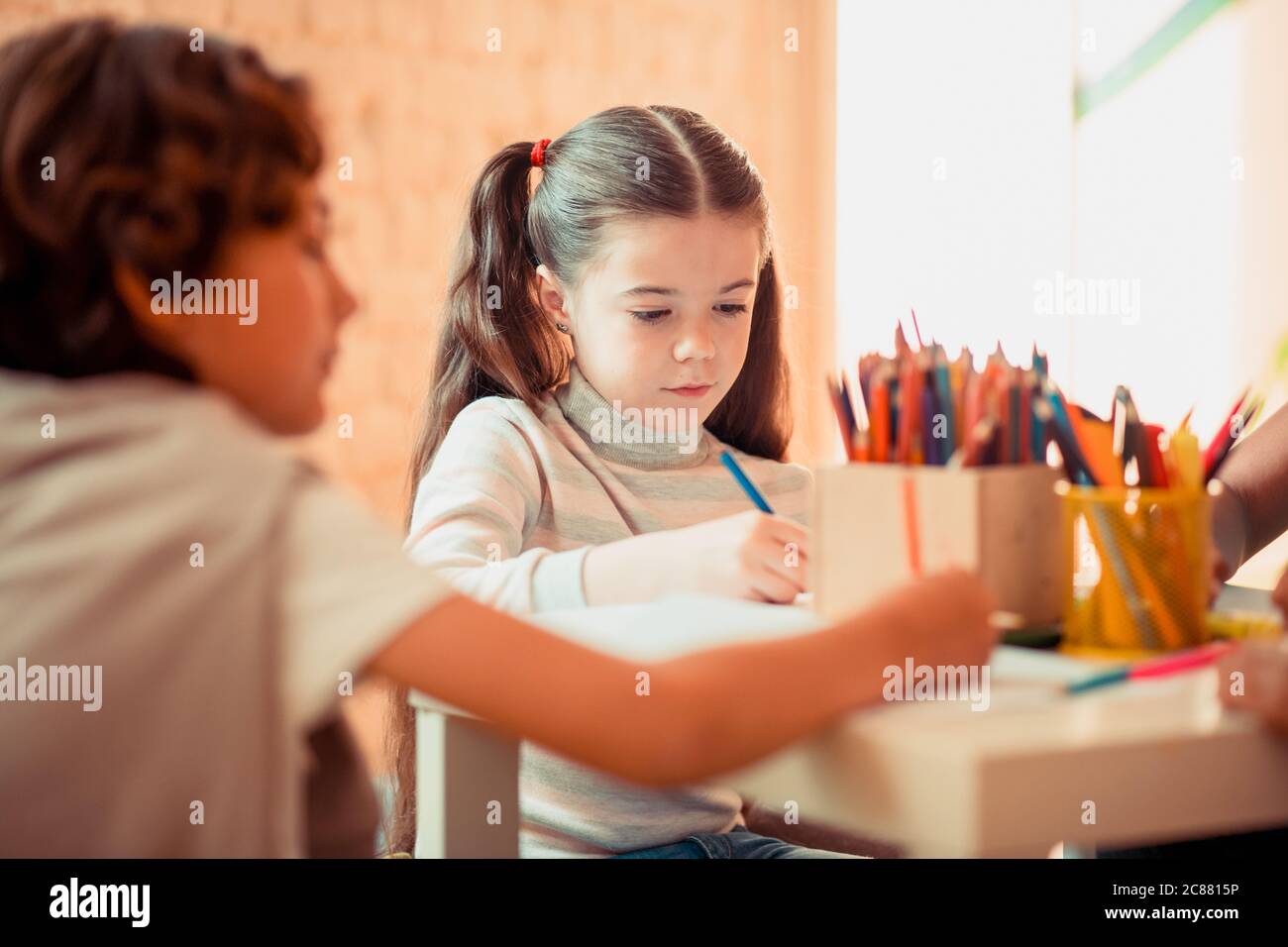 Concentrated girl drawind with color pencils during the art class Stock ...