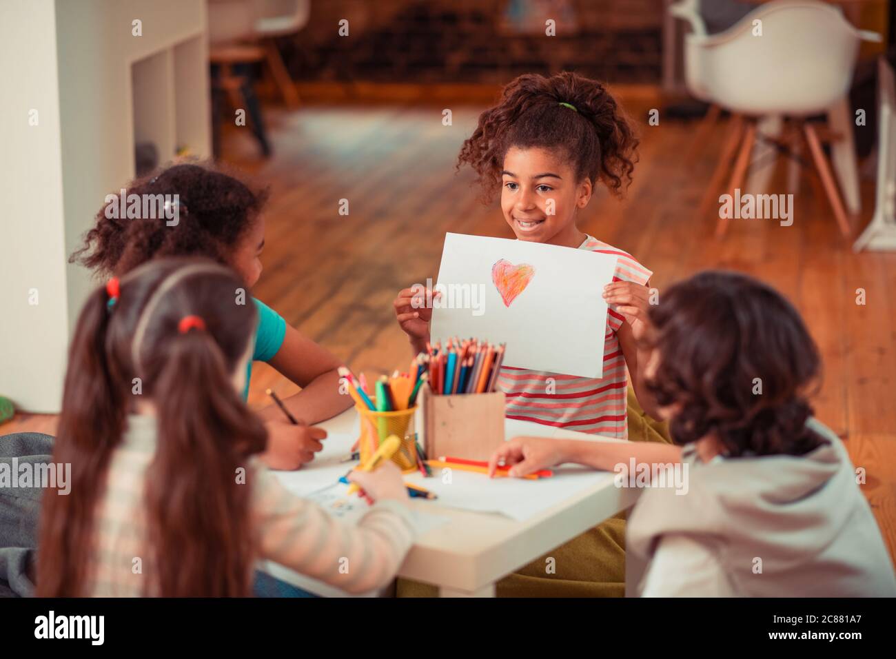 Girl showing a picture to her classmates Stock Photo - Alamy