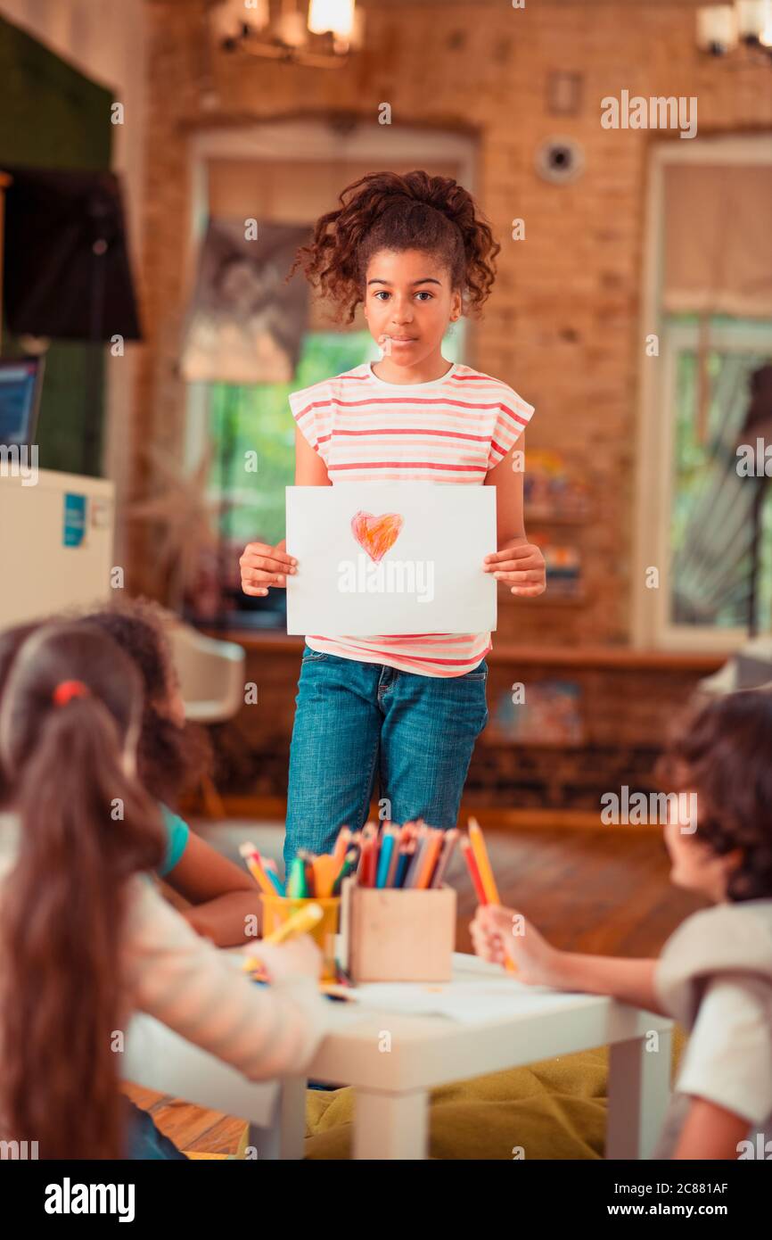 Girl showing a picture of the heart she drew Stock Photo - Alamy