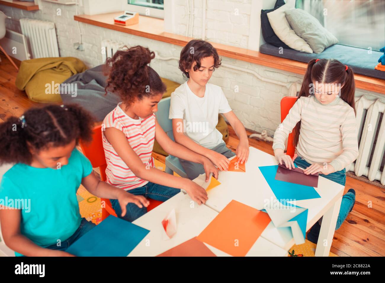 Children making colorful origami figures in the group Stock Photo - Alamy
