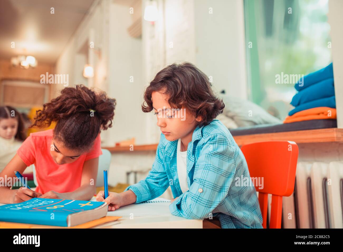 Concentrated boy solving math problems at class Stock Photo - Alamy