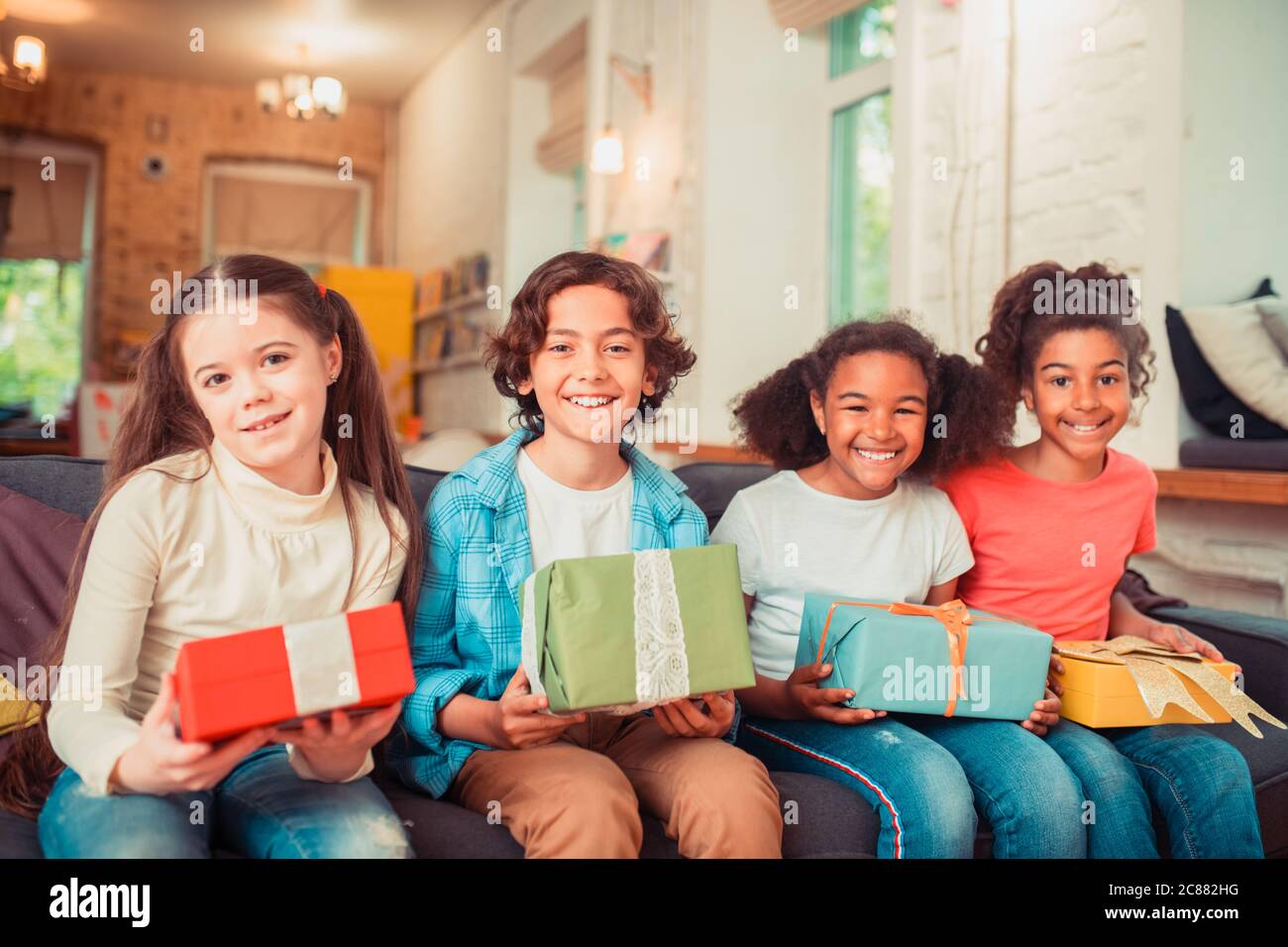 Happy children getting presents in colorful wrapping Stock Photo - Alamy