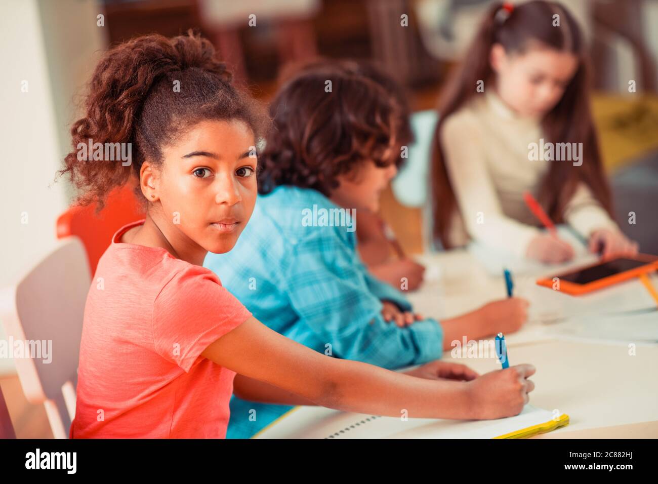 Girl doing her writing assignment at school Stock Photo - Alamy