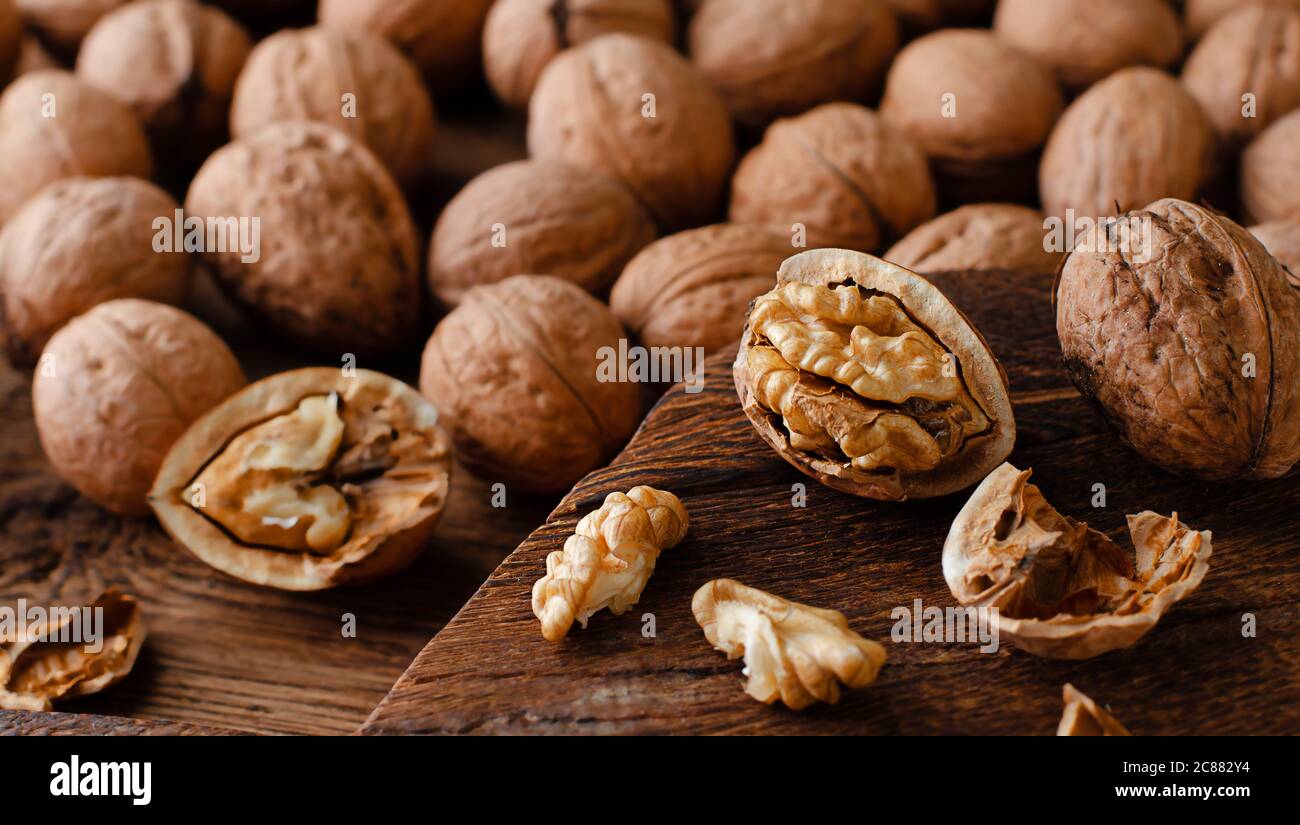 Walnut kernels in a shell on rustic wooden table. Healthy eating Stock ...