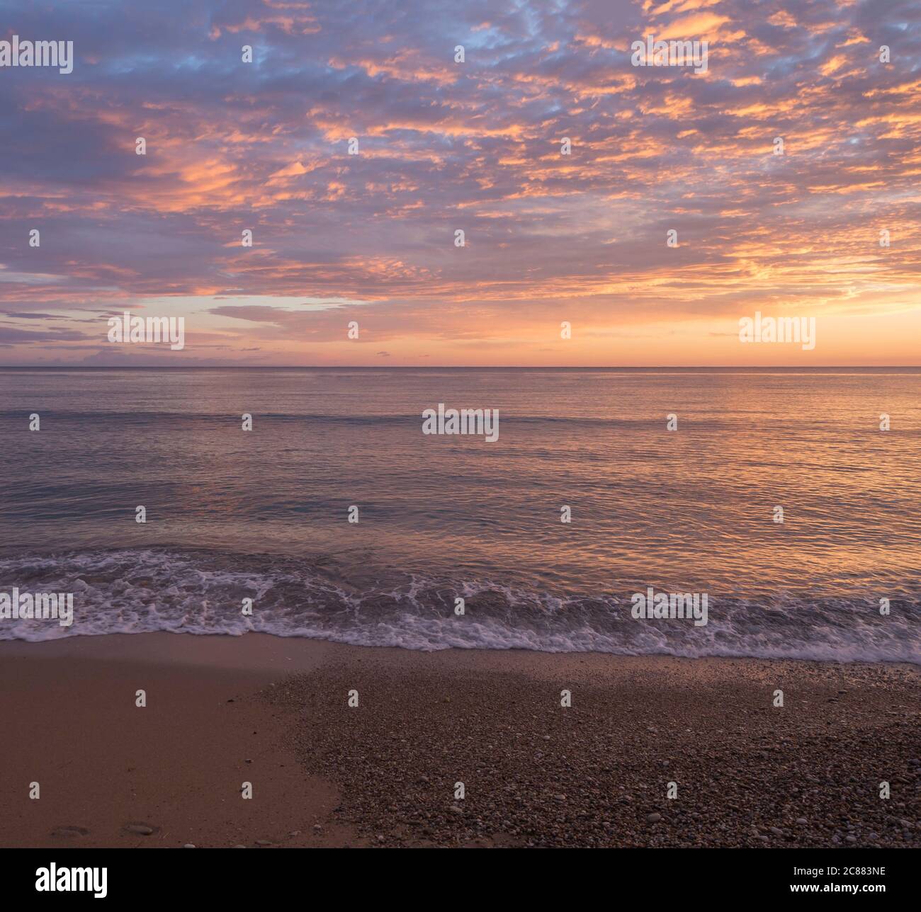 beautiful pastel pink orange and golden sunset clouds and waves at sea ...