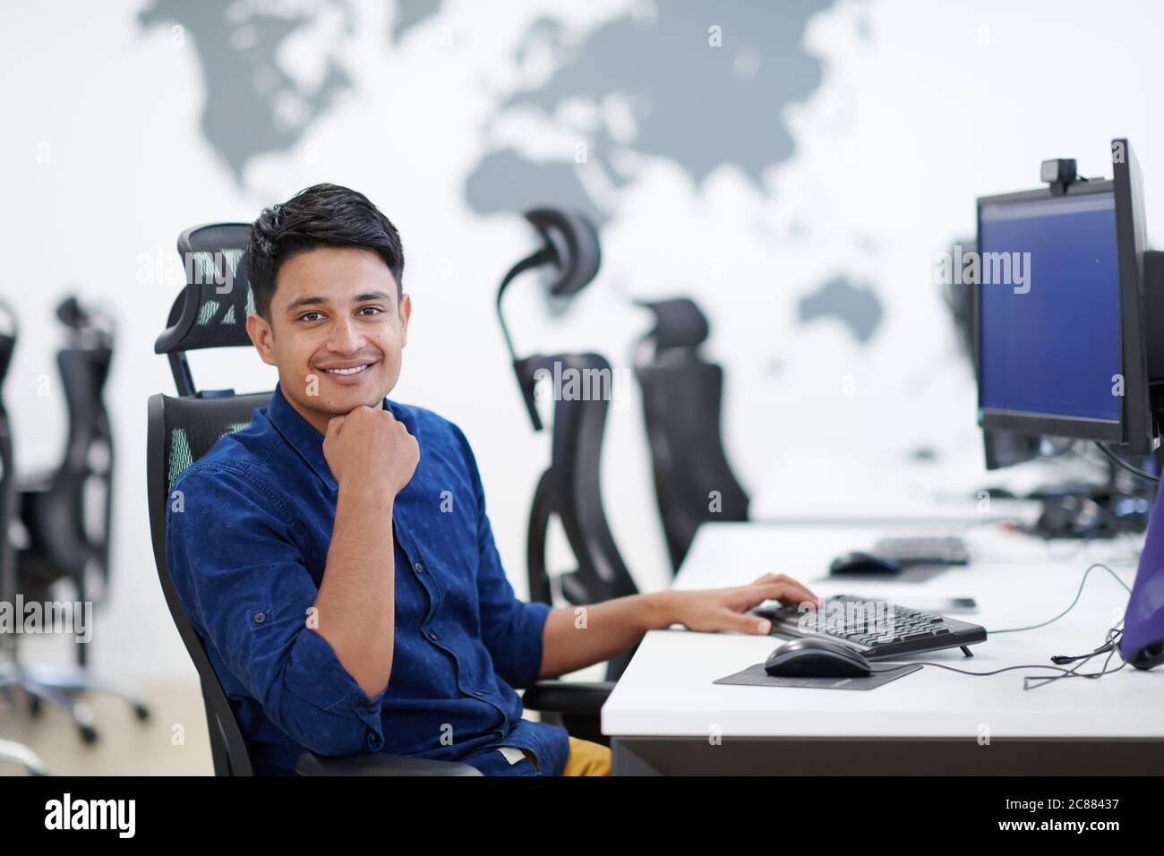 casual indian business man working on desktop computer in modern open ...