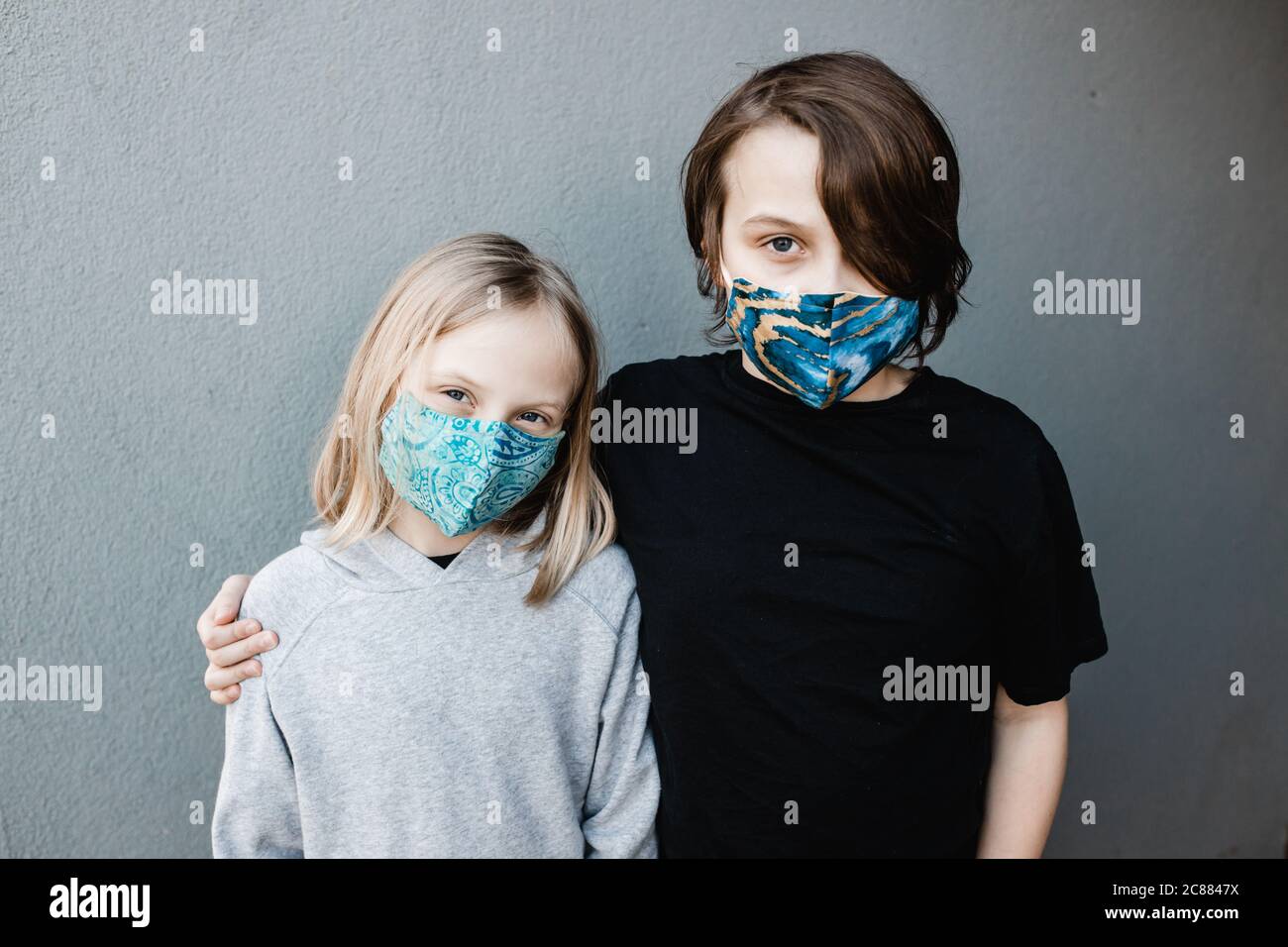 two children wearing fabric masks during the corona COVID-19 pandemic ...