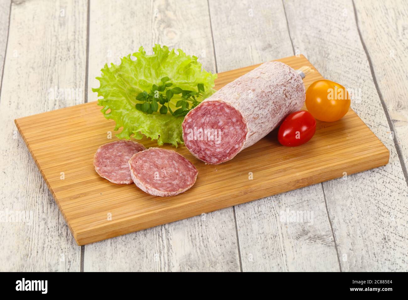 Italian dry Saliami pork sausage served salad leaves Stock Photo - Alamy
