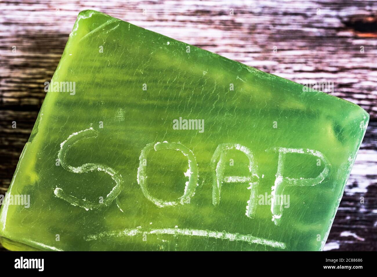 Close-up, shallow focus of a bar of natural soap with engraved letters ...