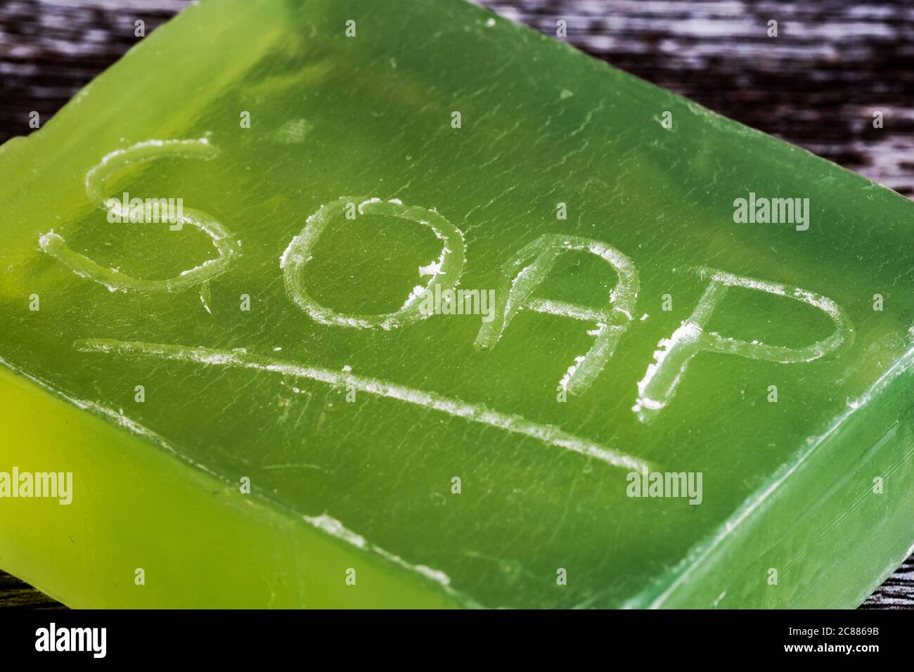 Close-up, shallow focus of a bar of natural soap with engraved letters ...