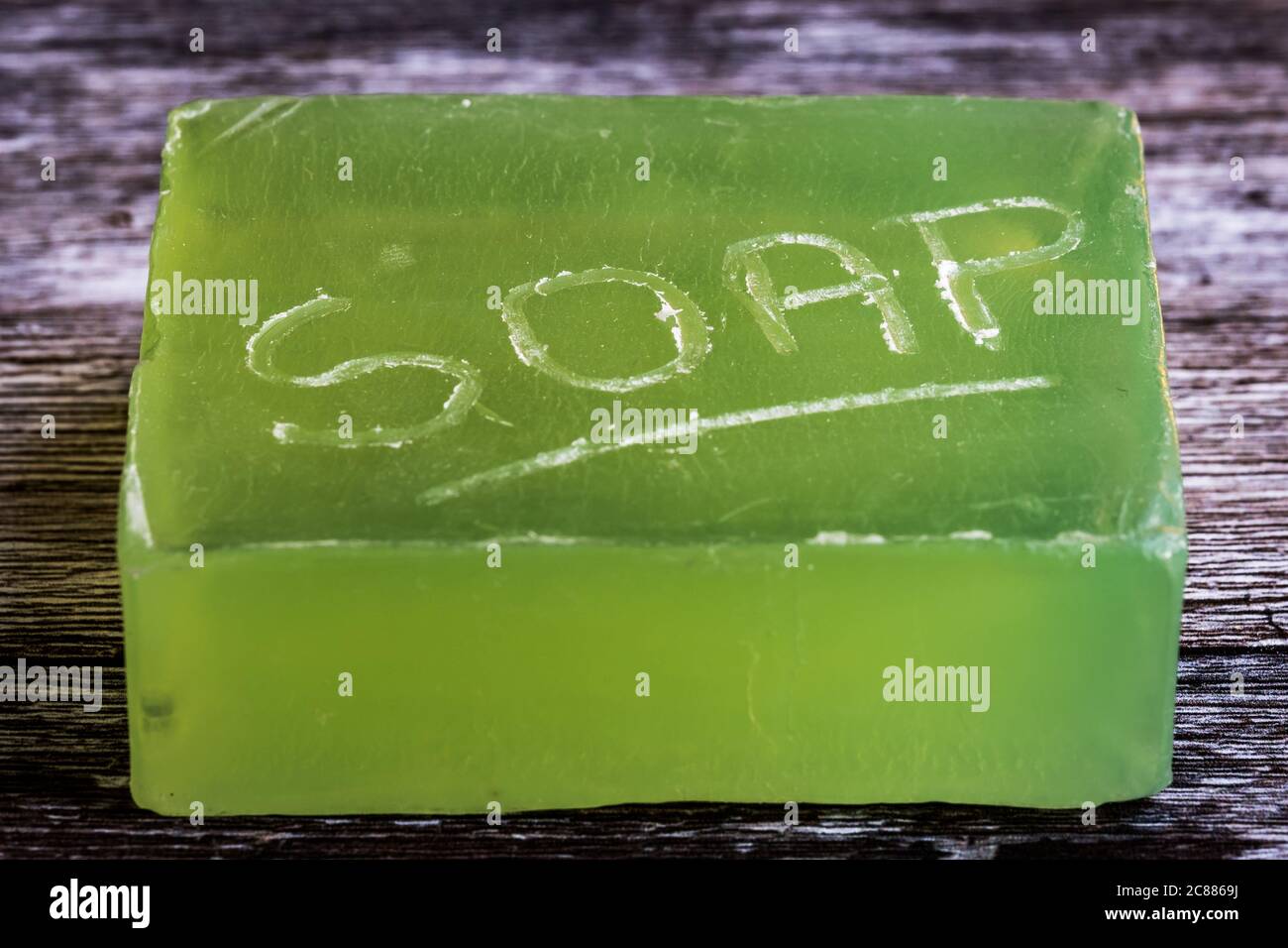 Close-up, shallow focus of a bar of natural soap with engraved letters ...