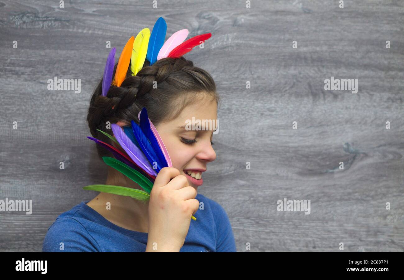 Beautiful little girl with colorful feathers in her hand and hair Stock ...