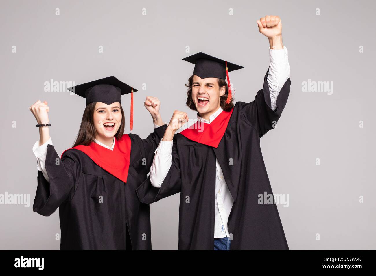 Couple in graduation gowns holding diplomas and celebrate isolated on ...