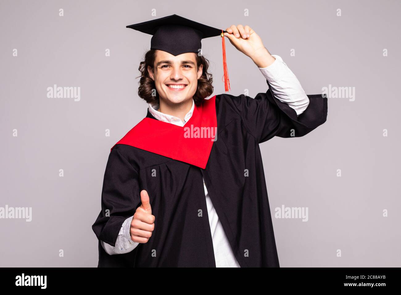 male graduation portrait smiling and standing over a white background ...