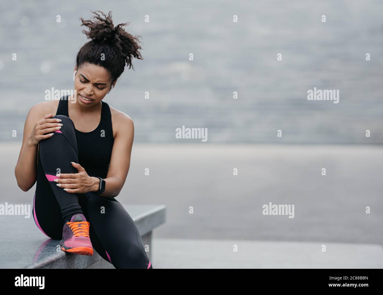 Sport injury during training. Sad girl sits and strokes leg Stock Photo ...