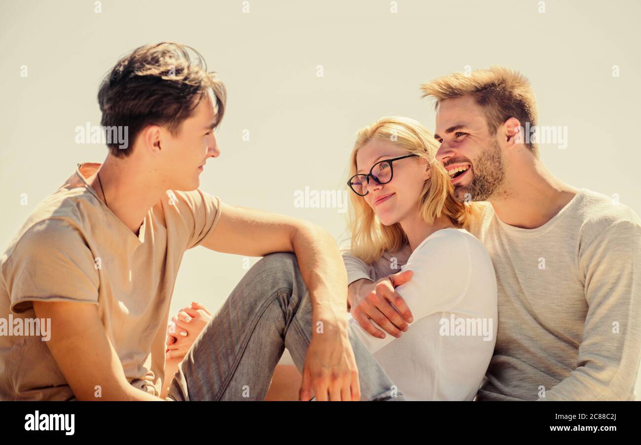 Friends relaxing on roof. Men and woman talking sky background ...
