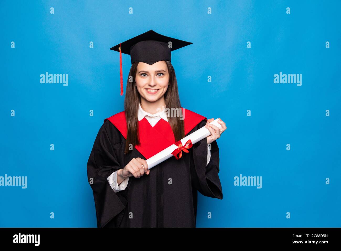 Beautiful woman wearing a blue graduation gown holding a diploma and ...