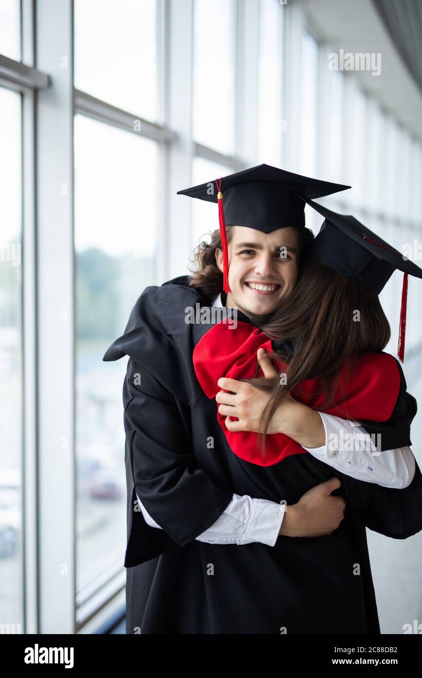 A graduates in the mantle embrace and enjoy. Beautiful graduate girl ...