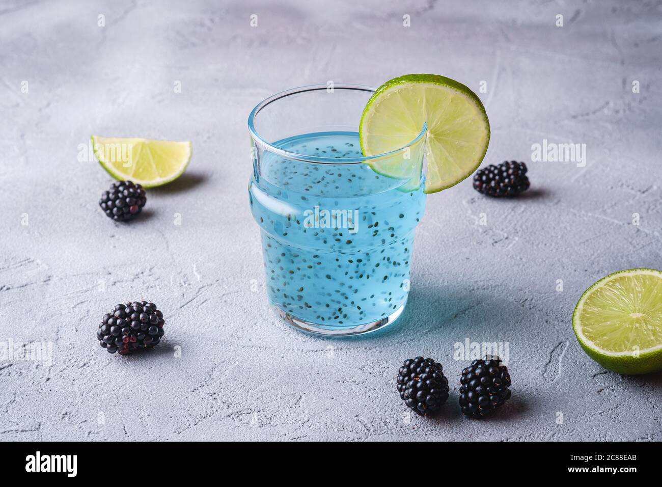 Tasty blue colored cocktail drink with basil chia seeds, citrus lime ...